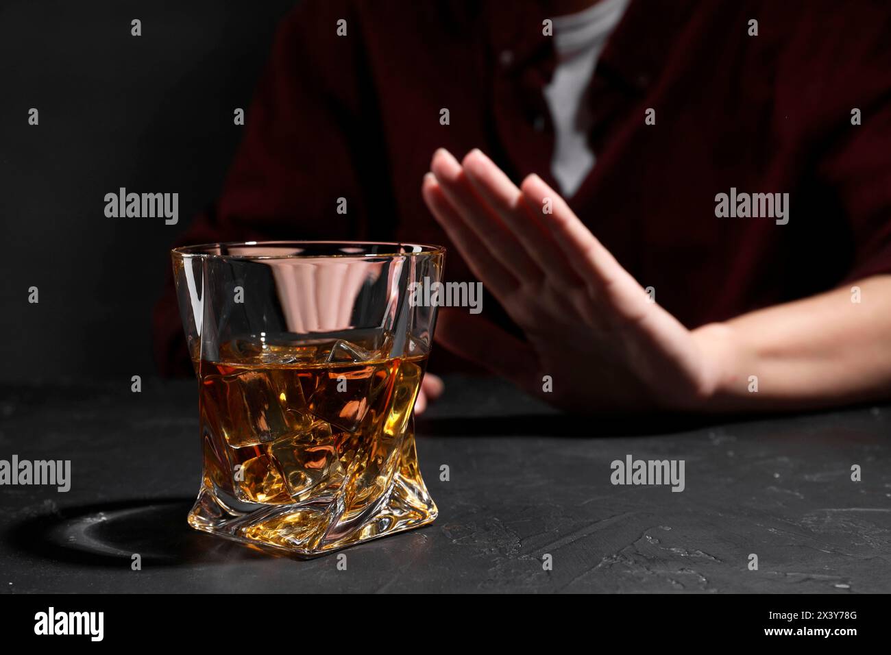 Alcohol addiction. Woman refusing glass of whiskey at dark textured ...