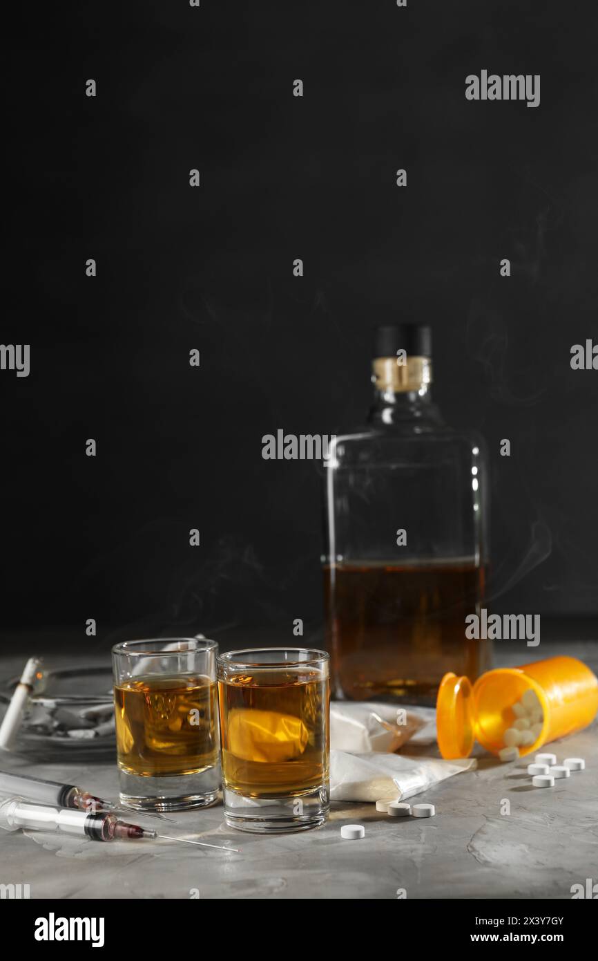 Alcohol and drug addiction. Whiskey in glasses, syringes, pills and ...