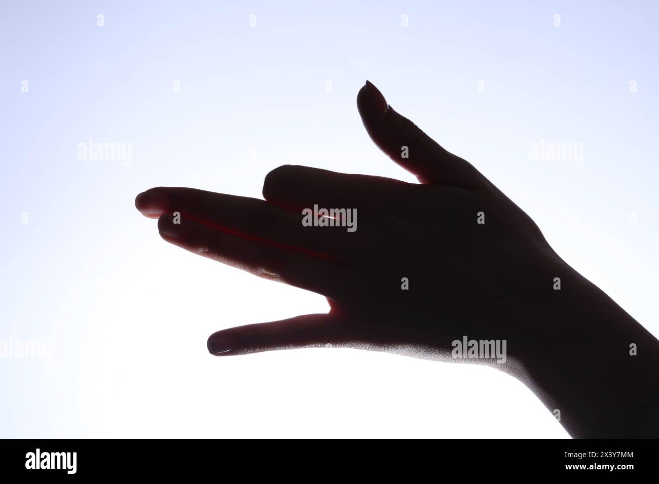 Shadow puppet. Woman making hand gesture like dog on light background ...