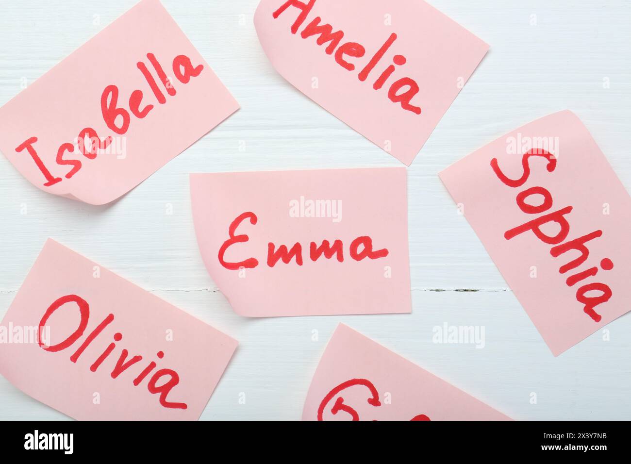 Paper stickers with different names on white wooden background, flat ...