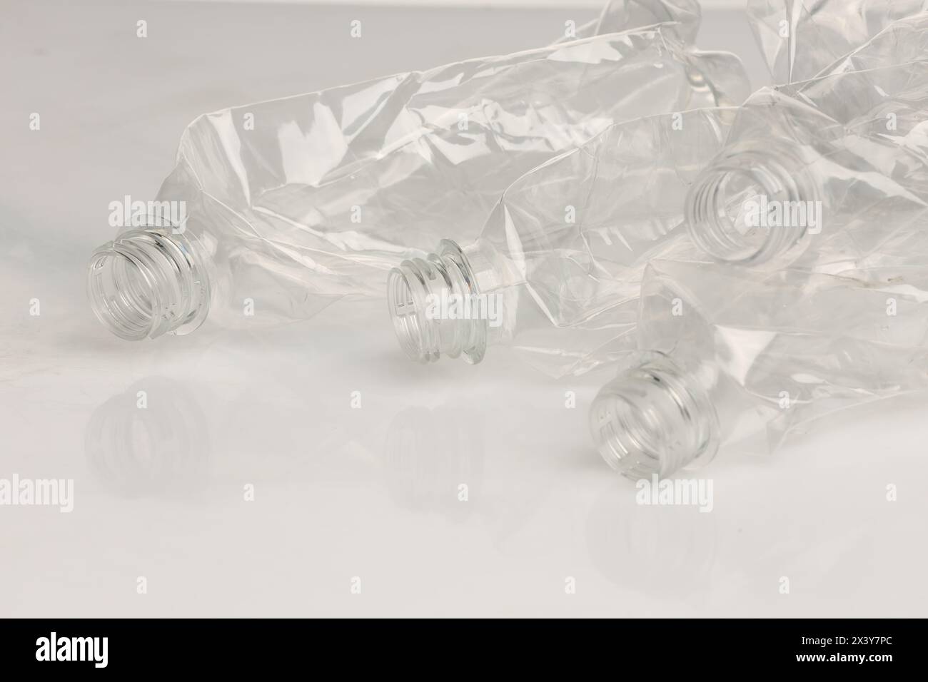 Crumpled disposable plastic bottles on white background Stock Photo - Alamy