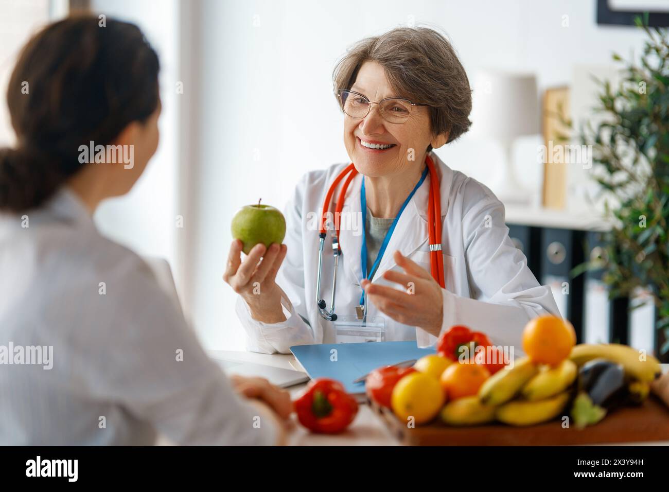 Happy doctor is working in medicine office. A woman is talking to a ...