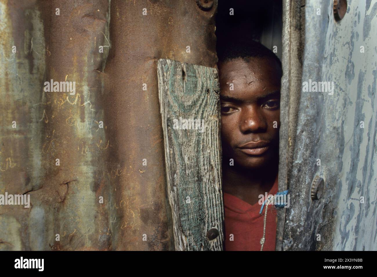Haitian man peering from his small shack home Stock Photo - Alamy
