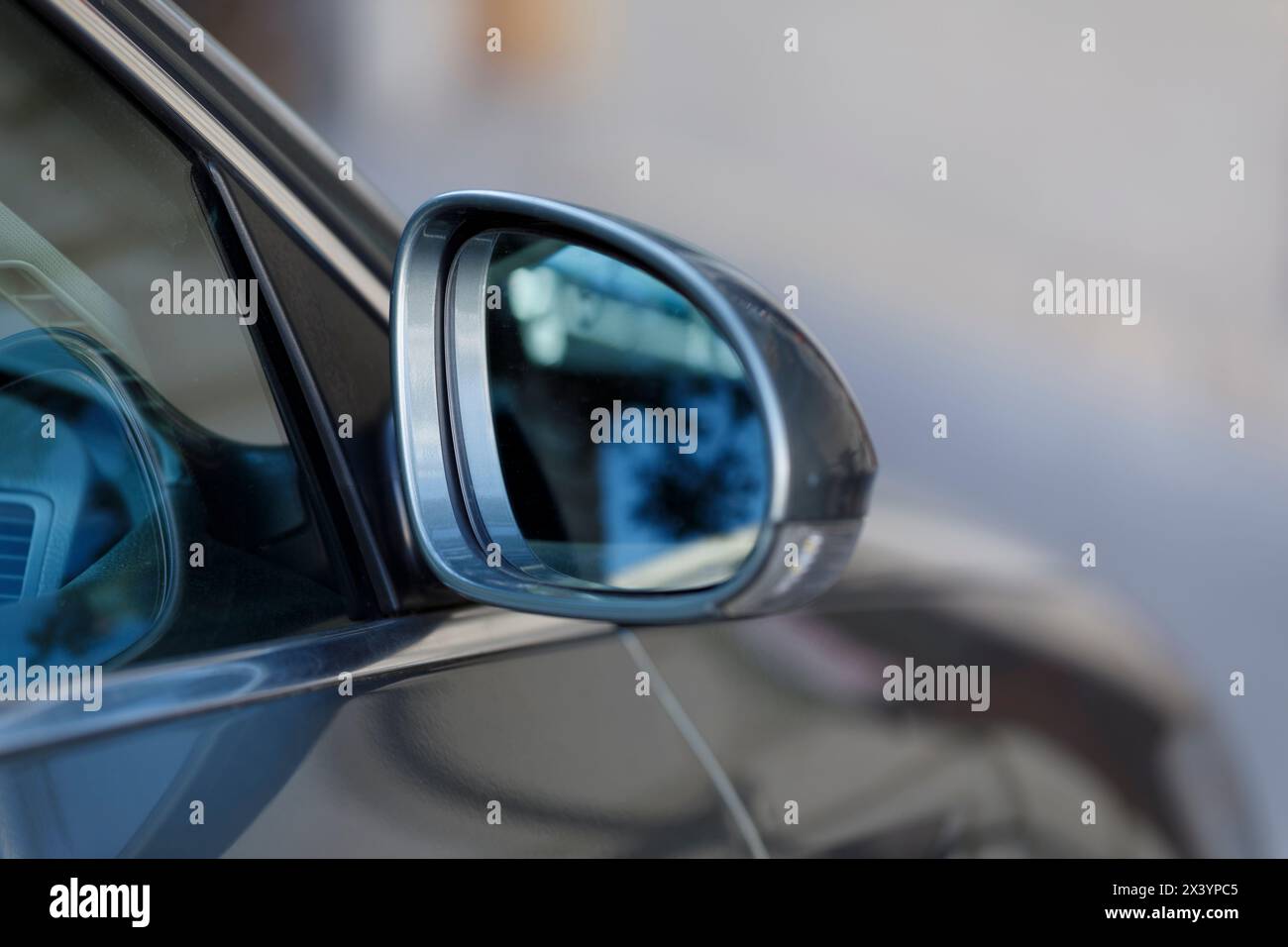 Car door and window detail with rear-view mirror, reflections on the ...