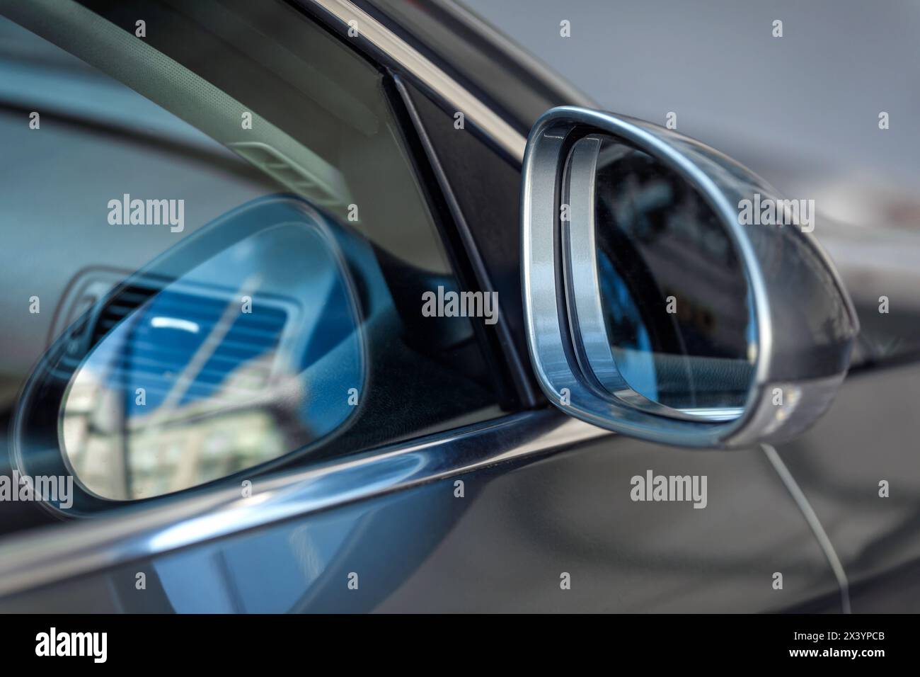 Car door and window detail with rear-view mirror, reflections on the ...