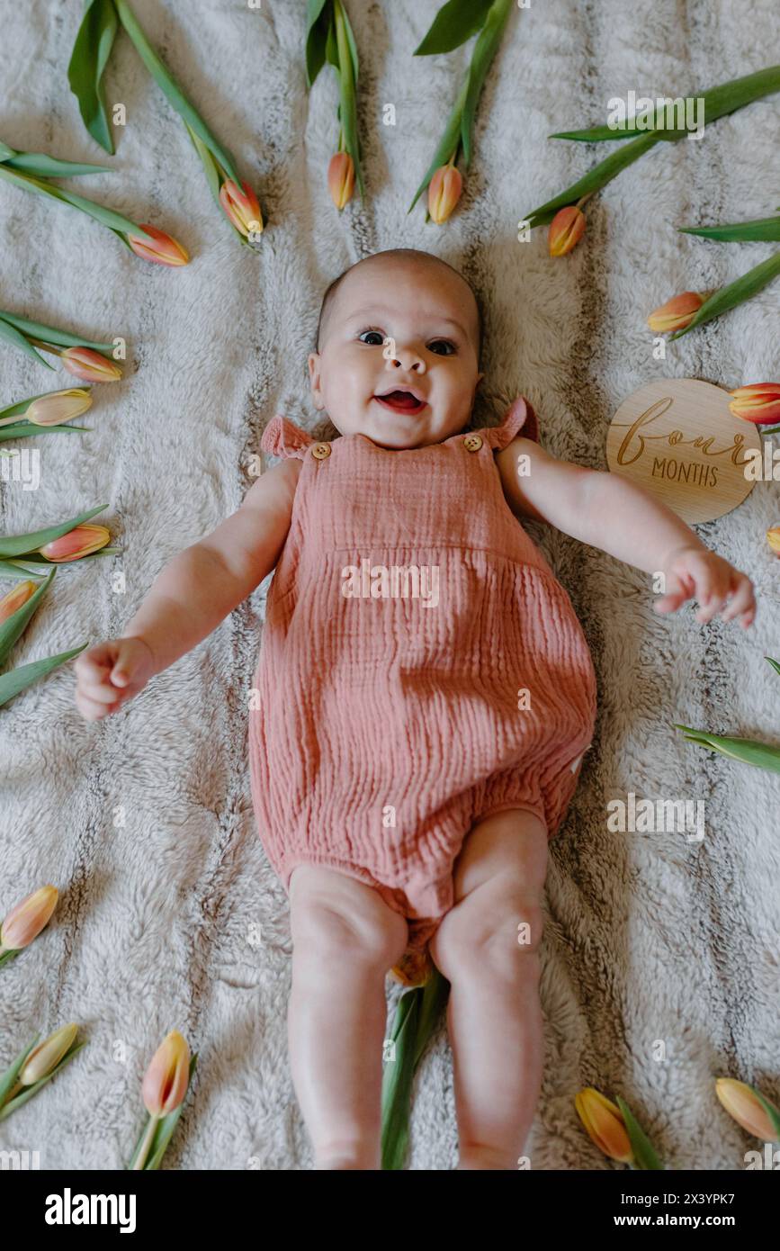 Baby's joy among tulips marks four months of wonder Stock Photo - Alamy