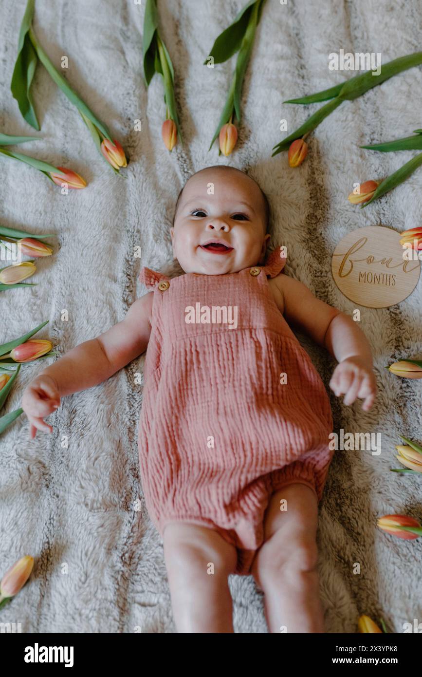 Baby's laughter blooms with tulips at four months Stock Photo - Alamy