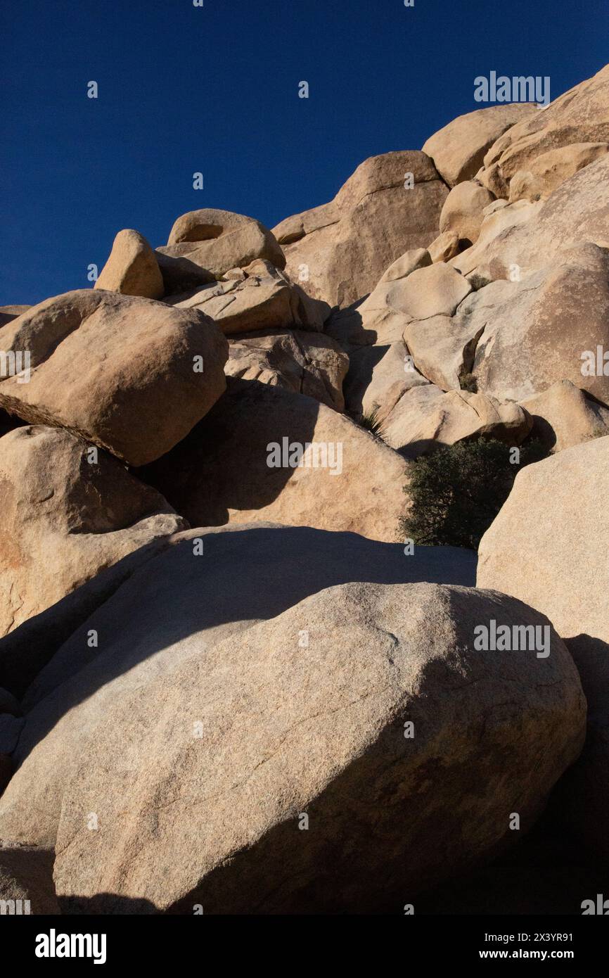 Monolithic boulders tower under the vast Joshua Tree sky Stock Photo ...