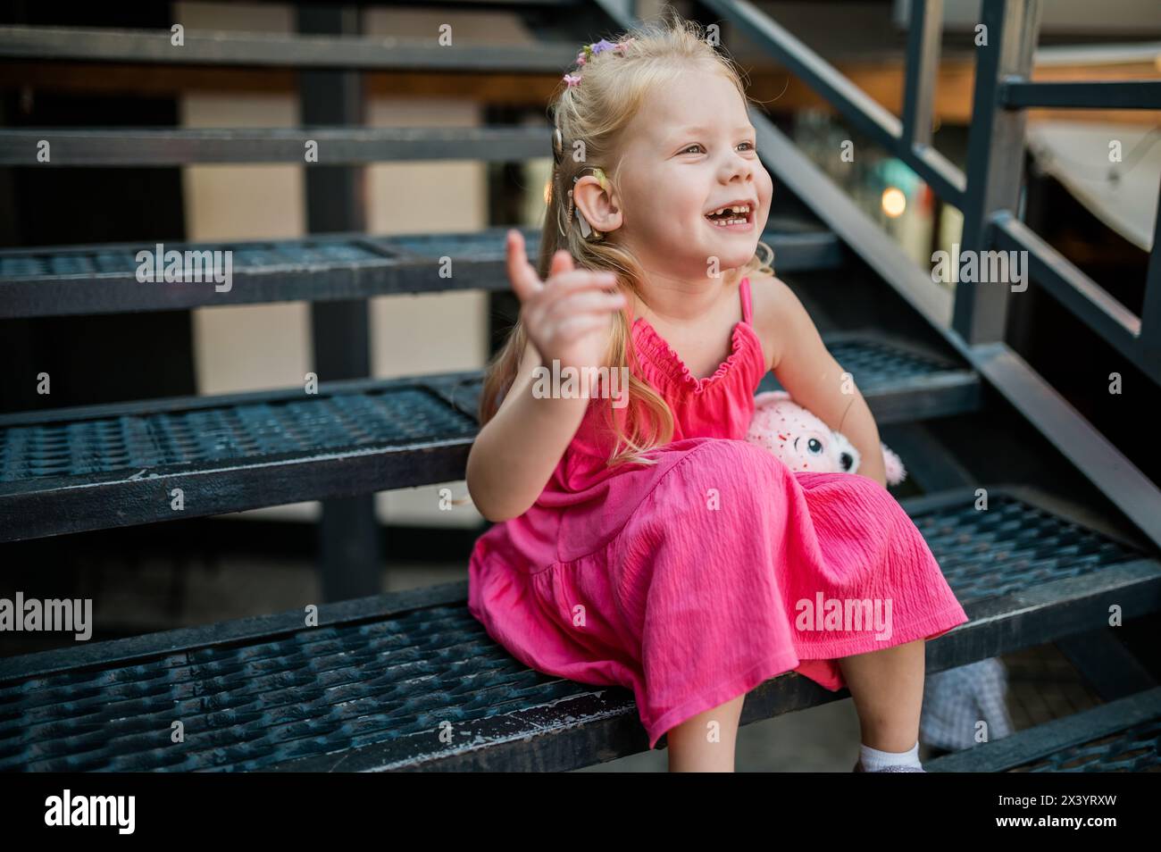 Child girl with hearing aids and cochlear implants having fun outdoor ...