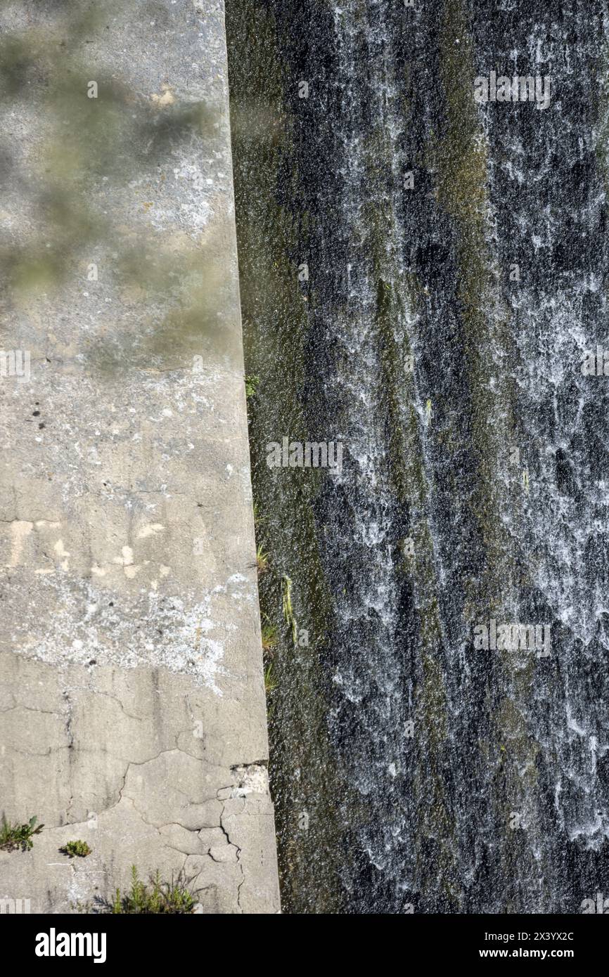 A concrete ramp surface to evacuate water from a dam full of weeds and ...