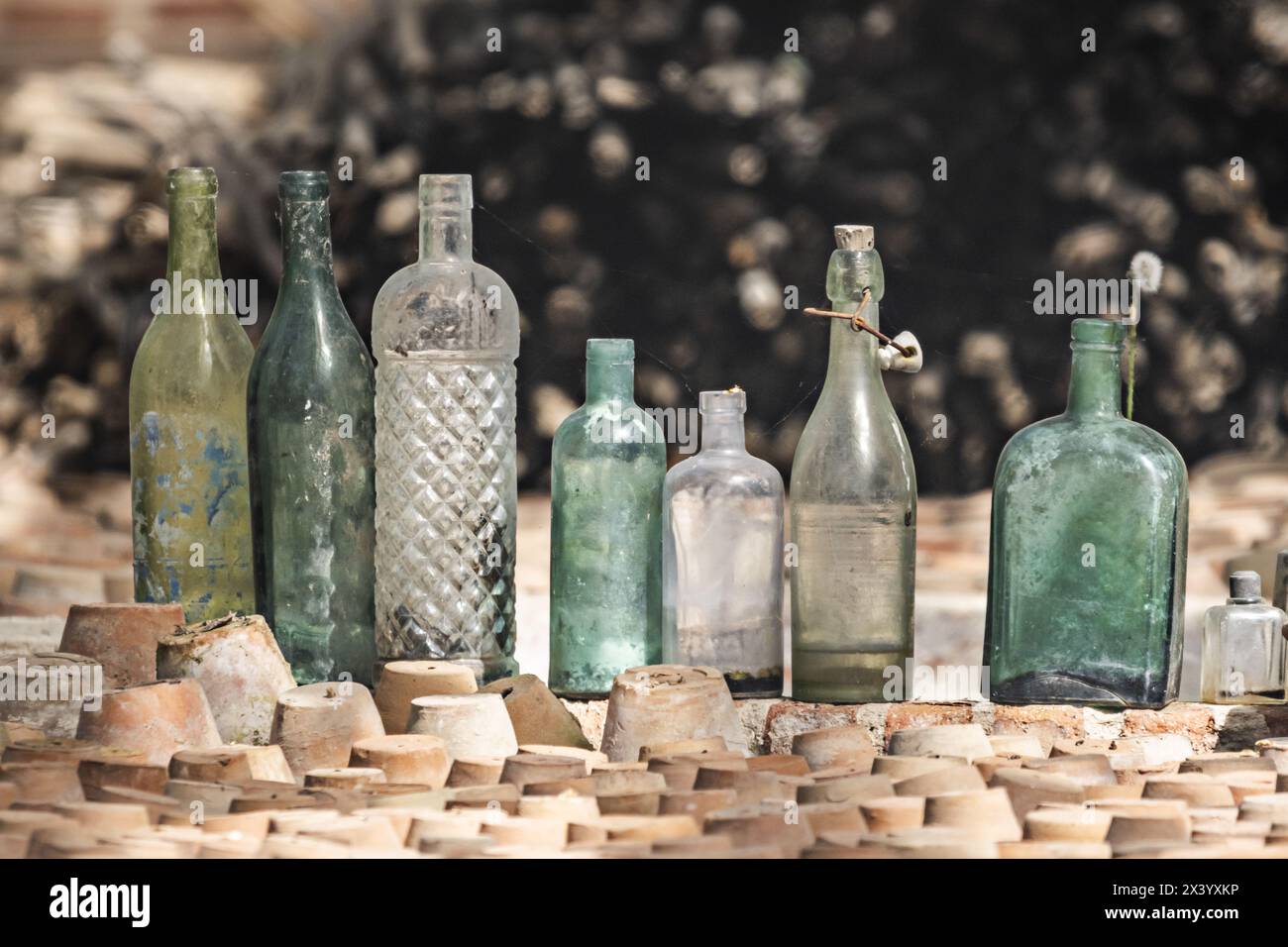 Antique glass bottles stacked next to terracotta pots Stock Photo - Alamy