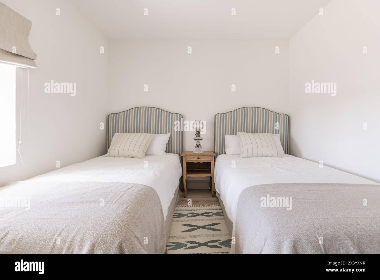 Bedroom with two single beds with shredded fabric upholstered ...