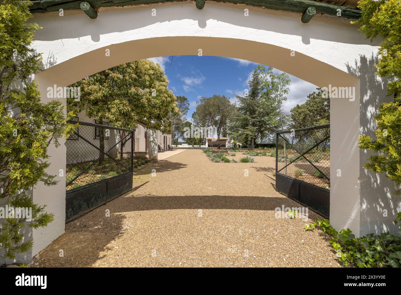 Entrance to a farm with gardens with trees, plants recently planted on ...