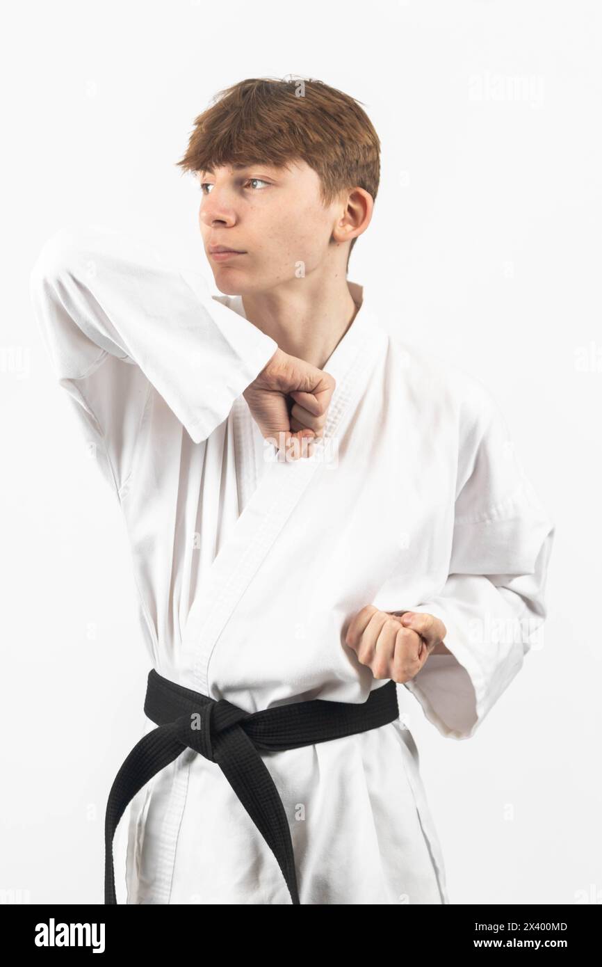 A 15 year old Karate Blackbelt boy, wearing A Gi performing an elbow ...