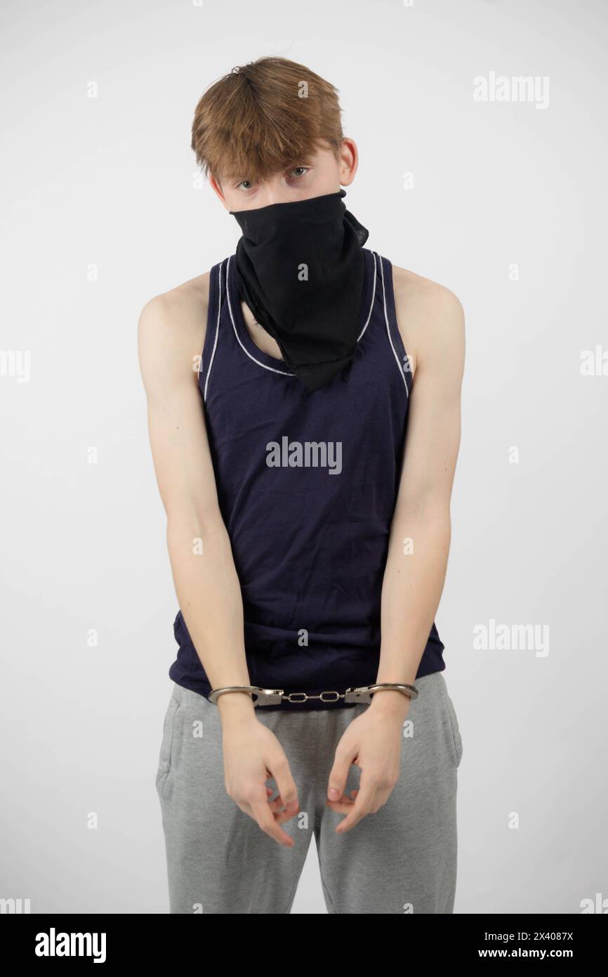A Teenage Boy Wearing a Mask, Arrested in Handcuffs Stock Photo - Alamy