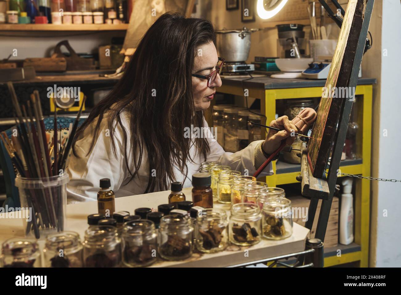 Artist at work on ancient painting restoration - Meticulous ...