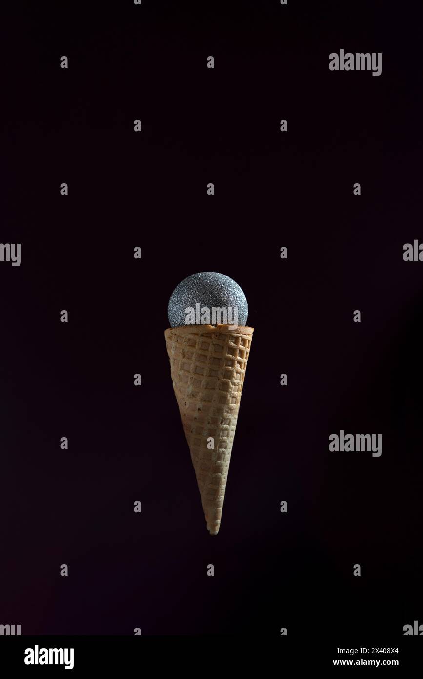 A microphone is placed inside of an ice cream cone. The cone is upside ...