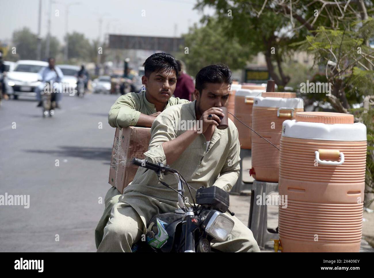Commuters are drinking chilled water to beat the heat of sun at a camp ...