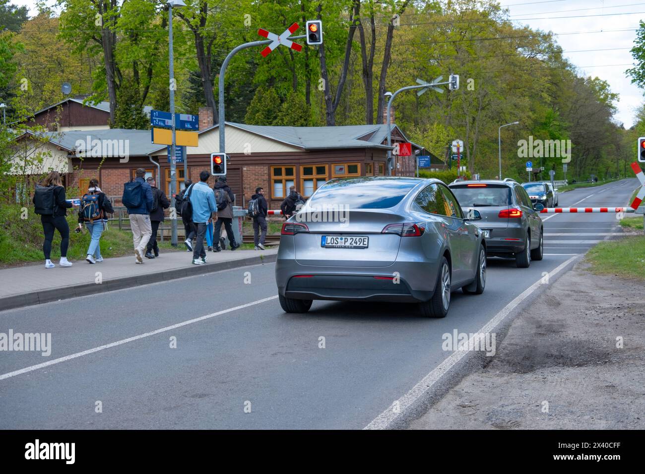 Tesla model y electric car stands in front barrier at railway crossing ...