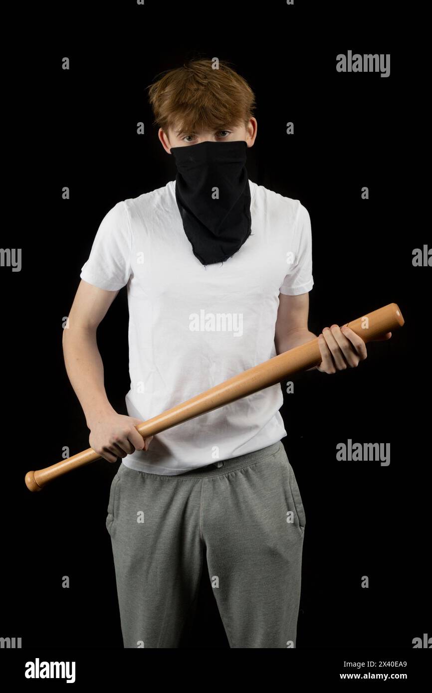 A Teenage Gang Member with a Baseball Bat and Mask against a balck ...