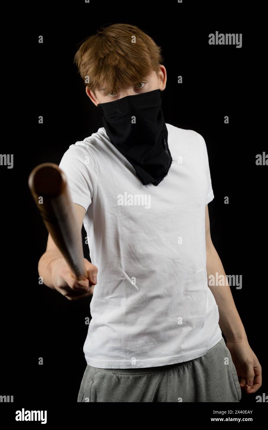 A Teenage Gang Member with a Baseball Bat and Mask against a balck ...