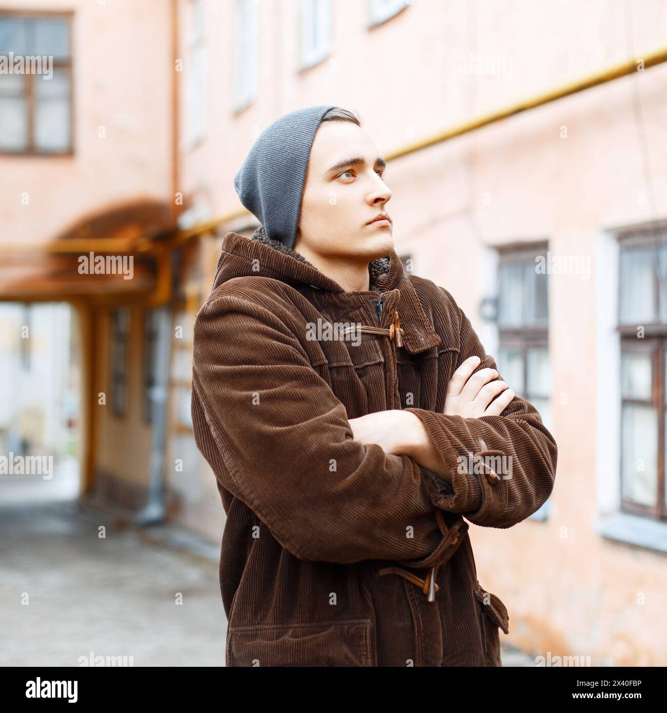 Handsome Young Man In A Hat And Coat Standing In The Courtyard Of Slums ...
