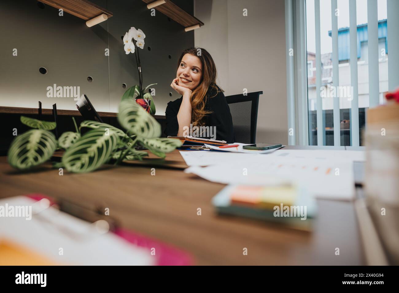 Happy female professional enjoying a creative moment at her office desk ...