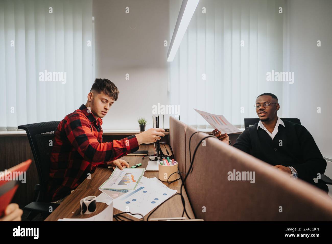 Young professionals in a modern office collaborating and discussing ...
