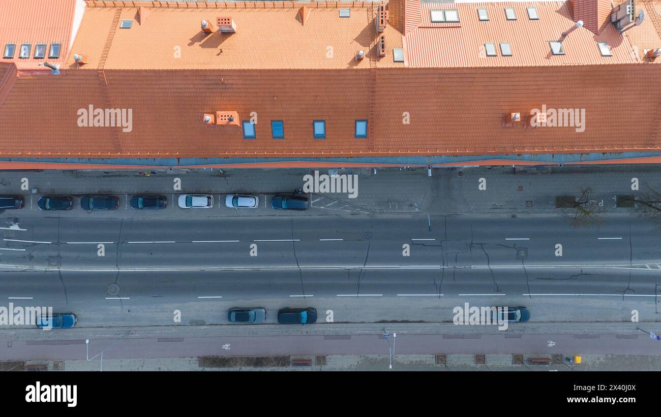 Drone photograph of a building rooftop, a street with parked cars ...