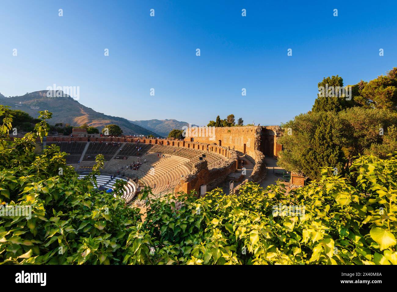 Tourists at the ruins of an ancient Greek theatre in the town of Taormina, Sicily, Italy ...