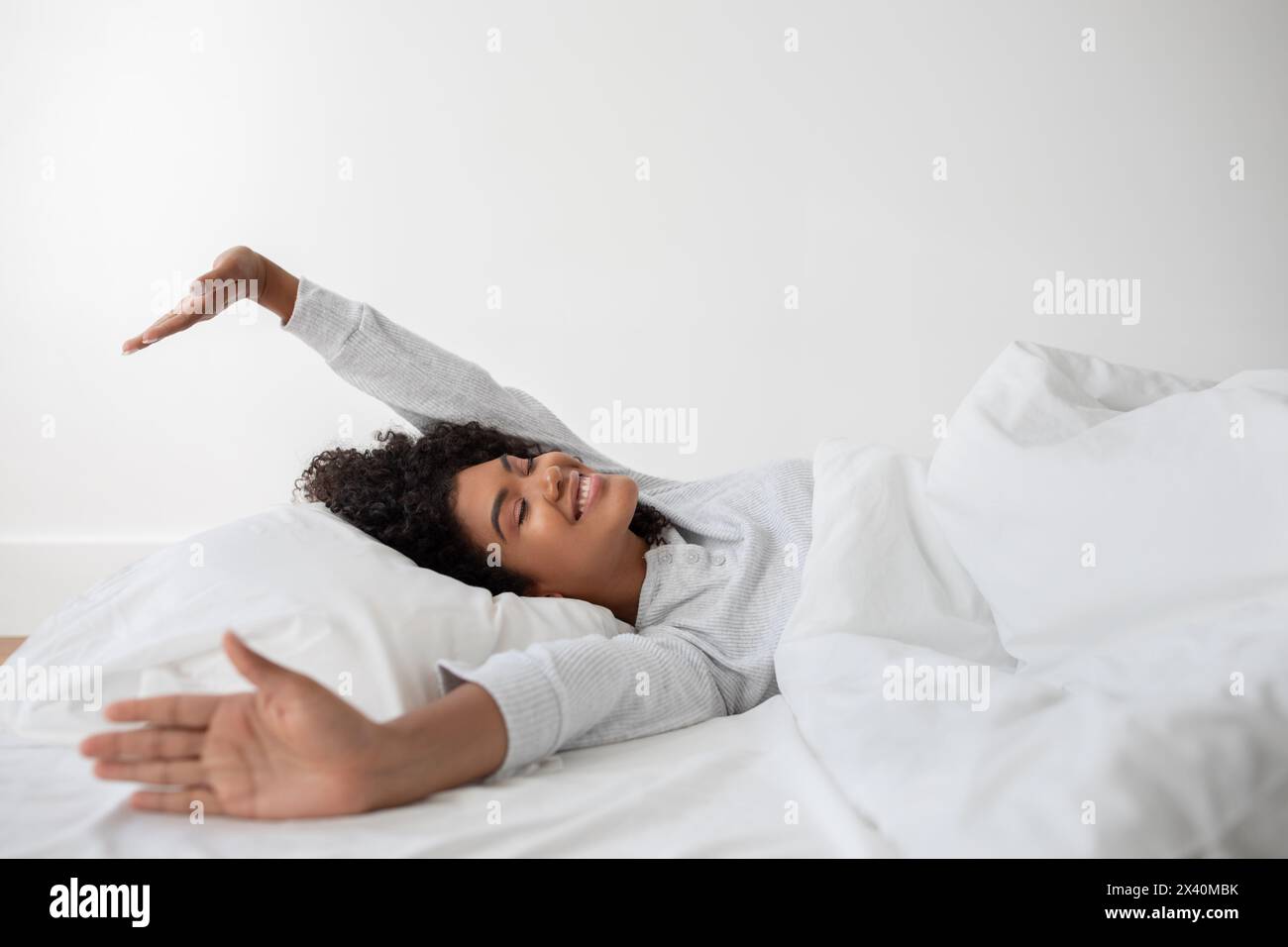 Woman Laying in Bed With Arms Outstretched Stock Photo - Alamy