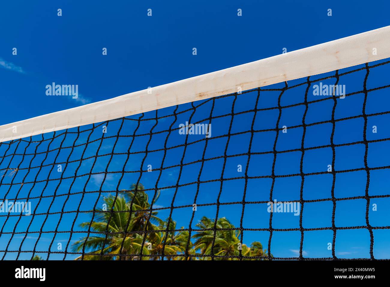 Close-up of the netting of a beach volleyball net against a blue sky ...