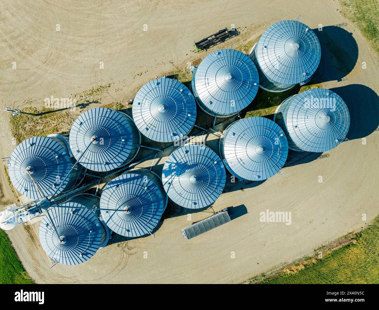 Aerial view looking straight down on rows of large metal grain bins ...
