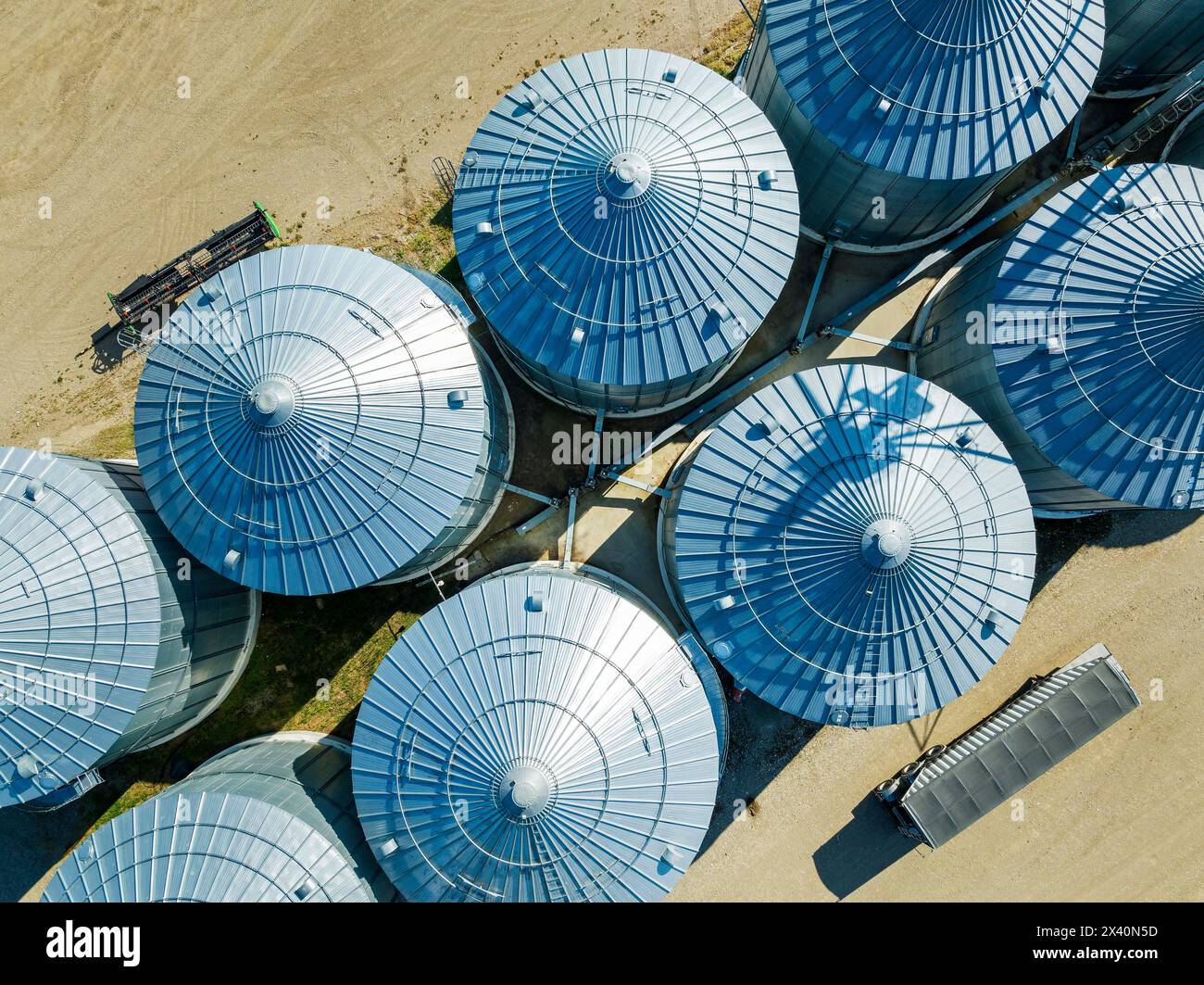 Aerial view looking straight down on rows of large metal grain bins ...