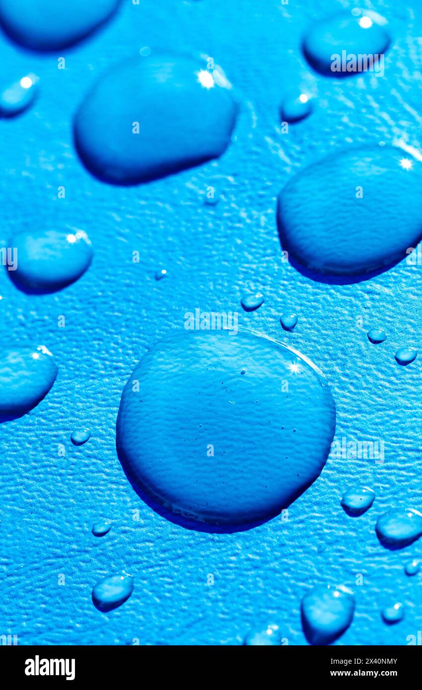 Close-up of large water droplets on a blue vinyl background; Studio ...
