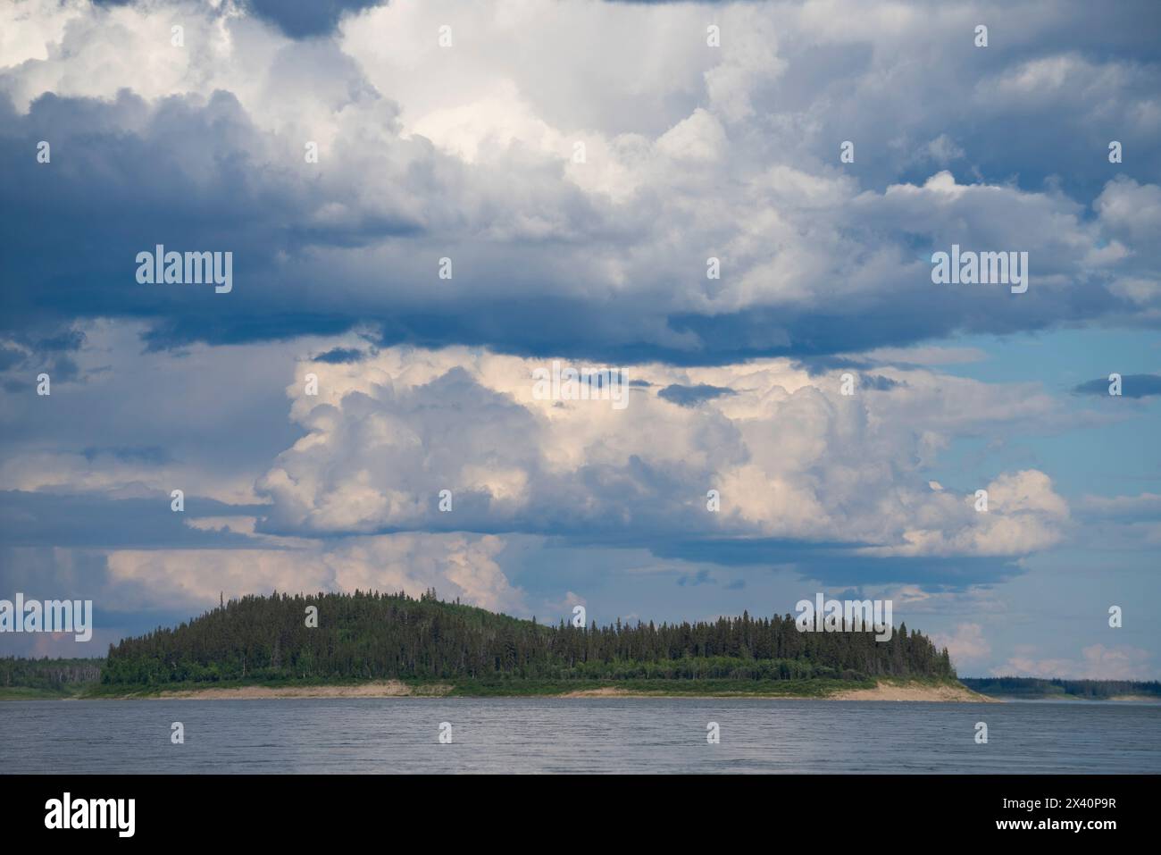 Summer clouds form over an island in the middle of the Mackenzie River ...