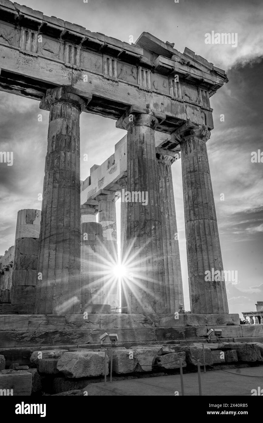 Sunburst glistens through the columns of the Parthenon at the Acropolis of Athens, Greece ...