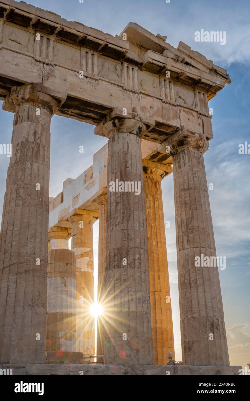 Close-up view of the columns of The Parthenon with a sunburst at twilight on the Acropolis of ...