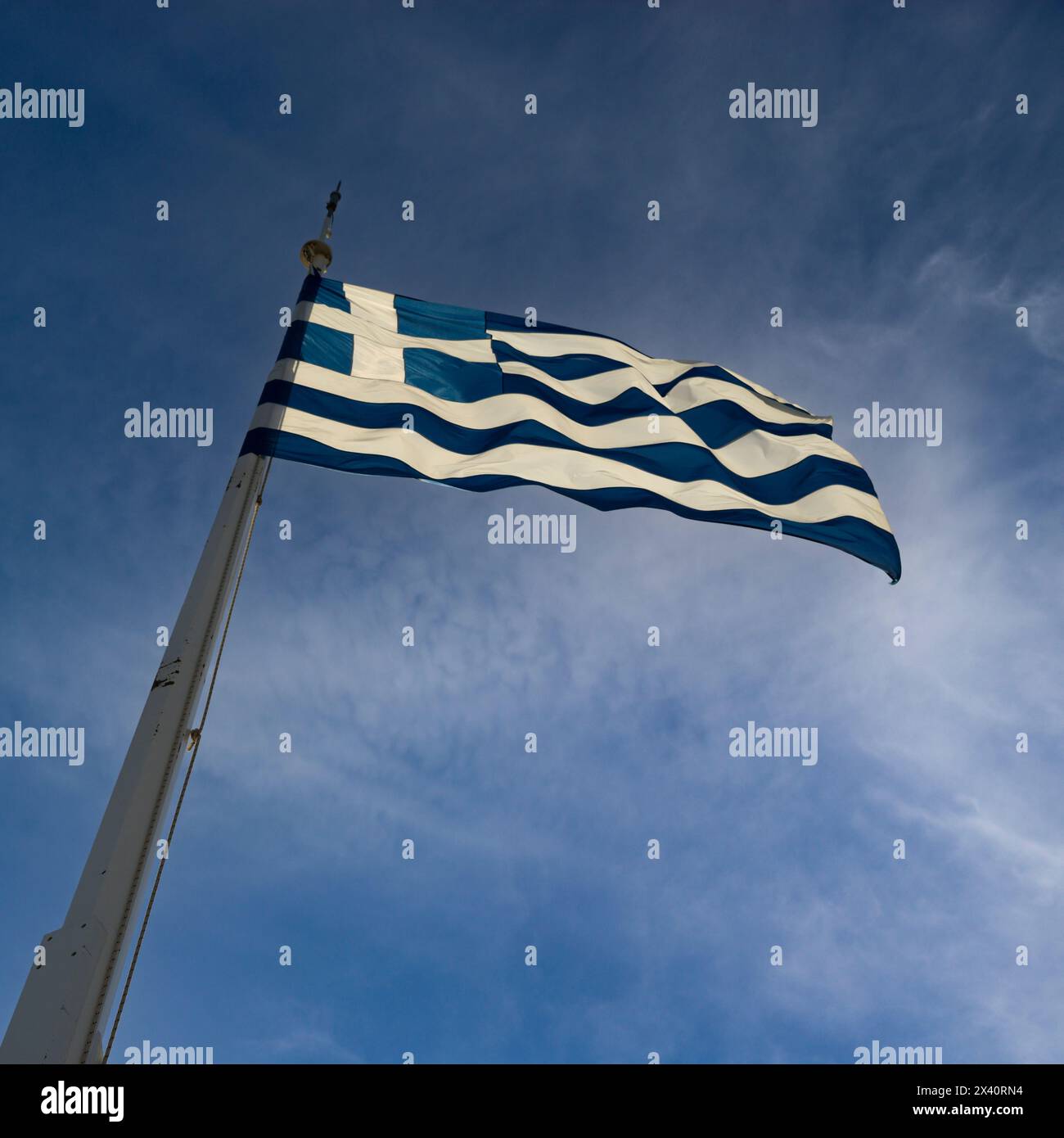 National flag of Greece flying in a blue sky with wispy clouds; Athens ...