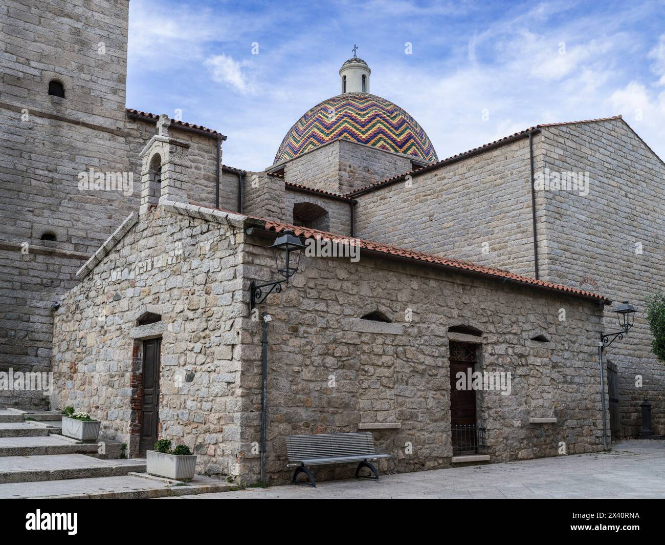 Church with colourful mosaic dome and weathered stone walls in Olbia ...