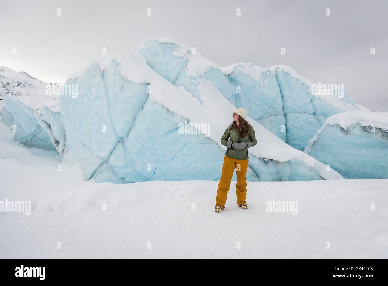 Teenage girl standing on the Matanuska Glacier in the middle of blue ...