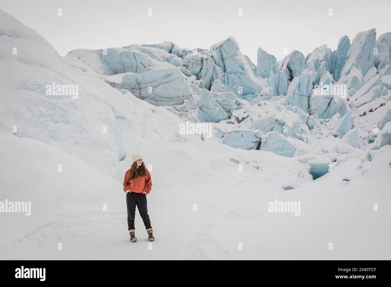 Teenage girl standing on the Matanuska Glacier in the middle of blue ...
