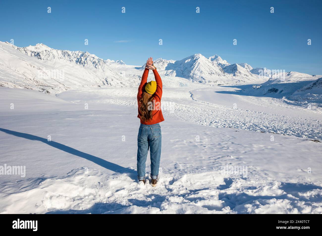 Teenage girl wearing an orange sweater and jeans looking away at the ...