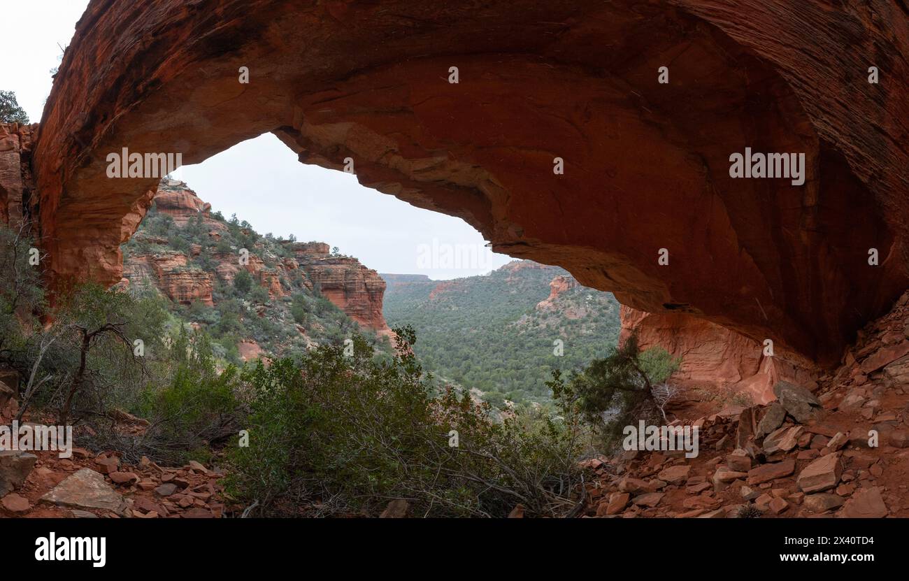 Panoramic image of red rock formation of a natural bridge along a ...