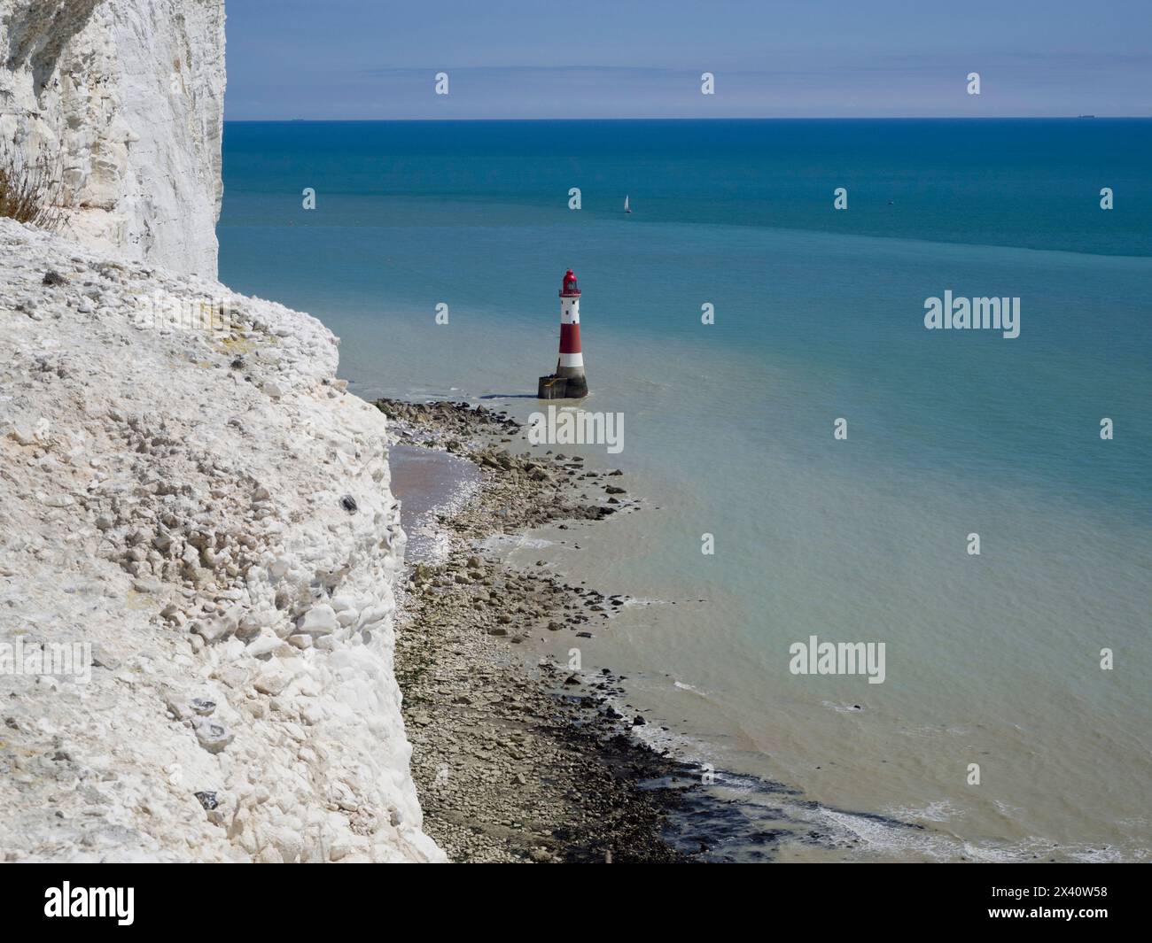 Beachy Head Lighthouse seen from the coast path above with white chalk ...