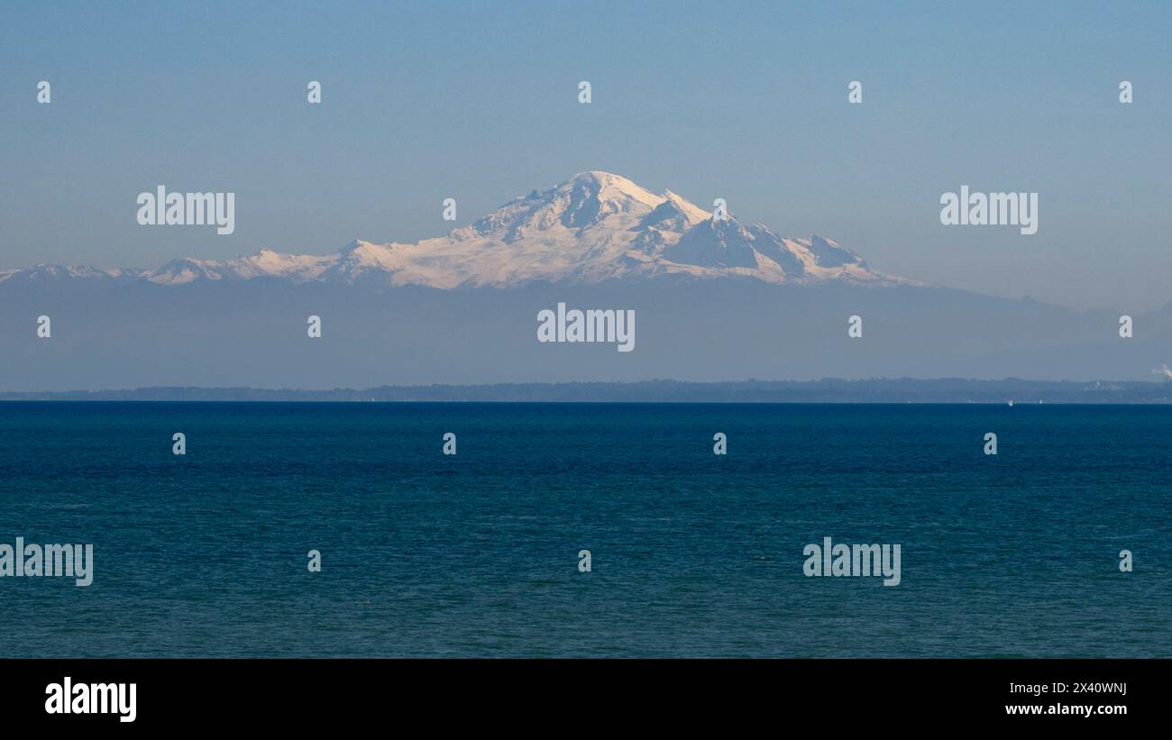 Snow-capped mountain peak under a blue sky viewed from the waters of ...