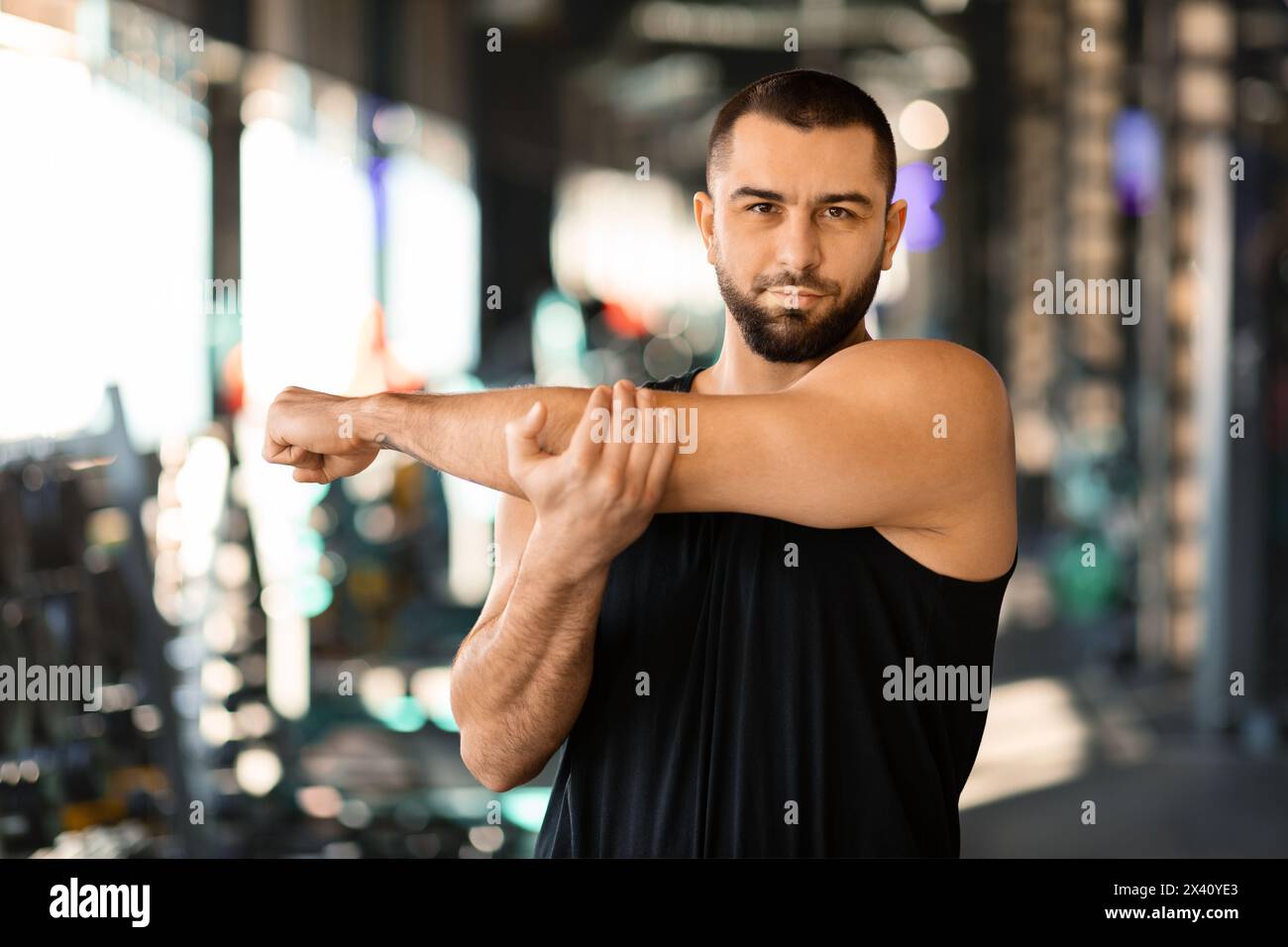 Man Stretching Arms Before Workout at a Sunny Gym Stock Photo - Alamy