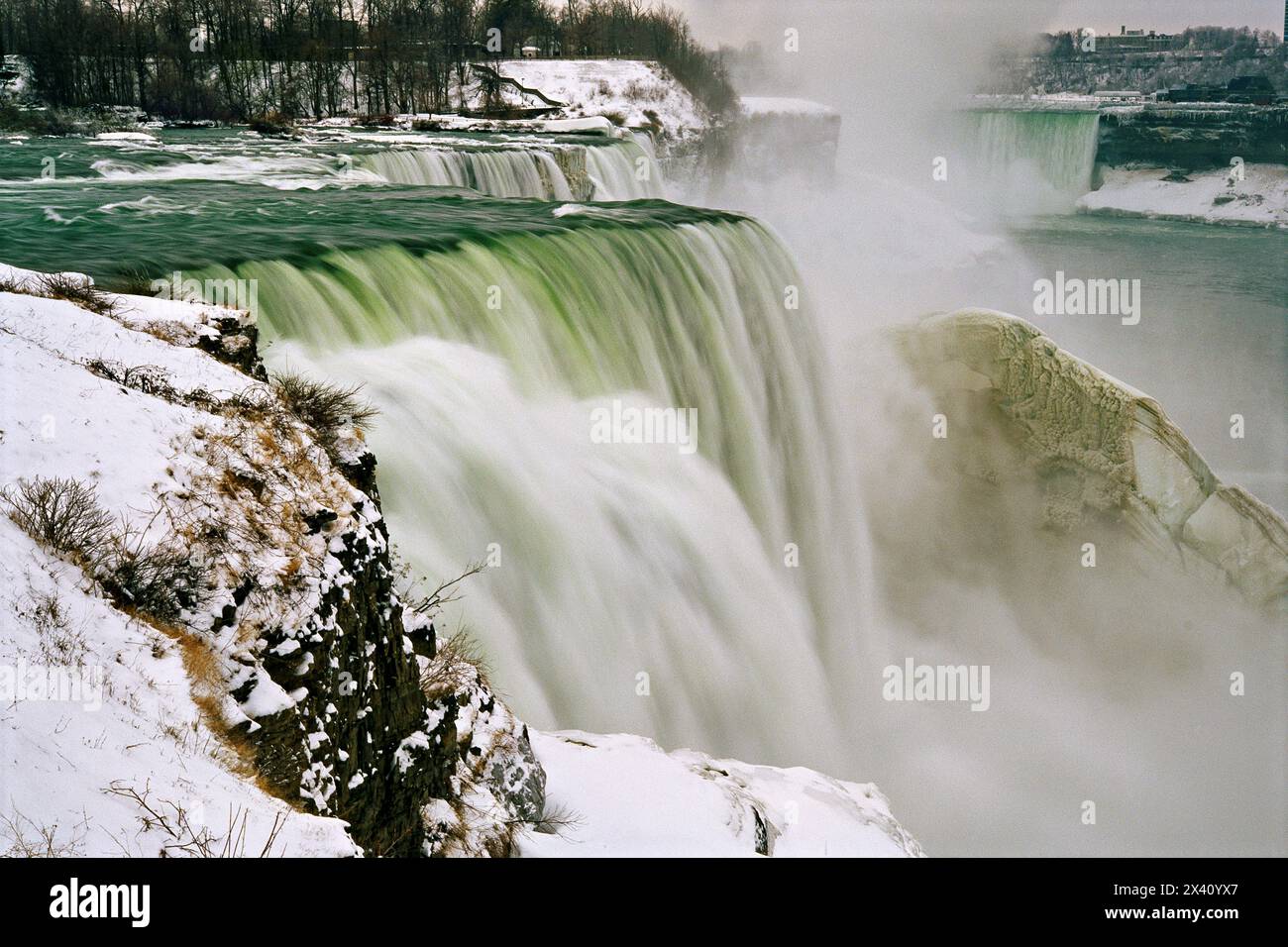 Winter view of cascading Niagara Falls where mist and spray form a ...