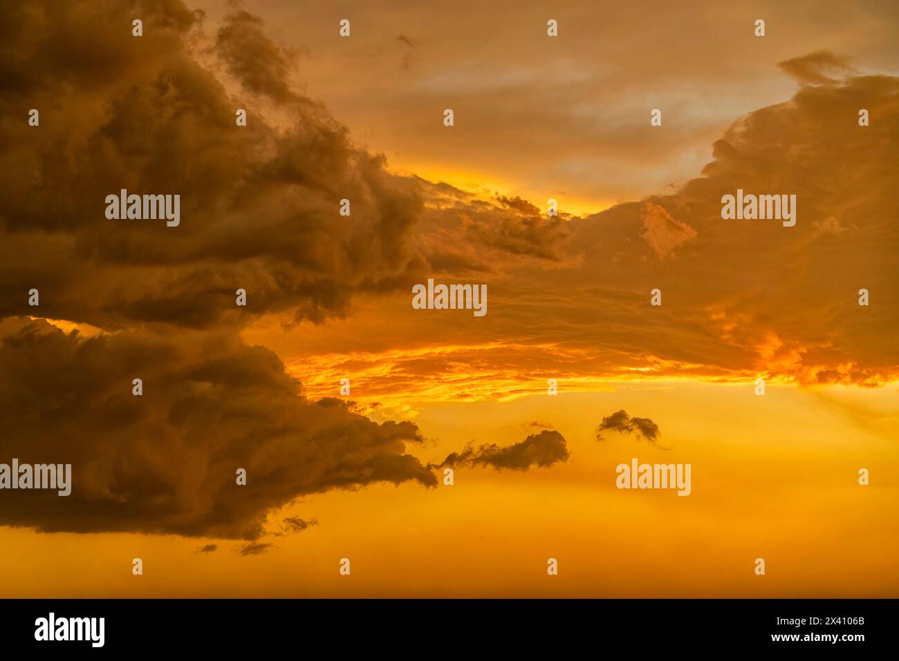 Clouds of a clearing thunderstorm ignite in colour as the setting sun ...