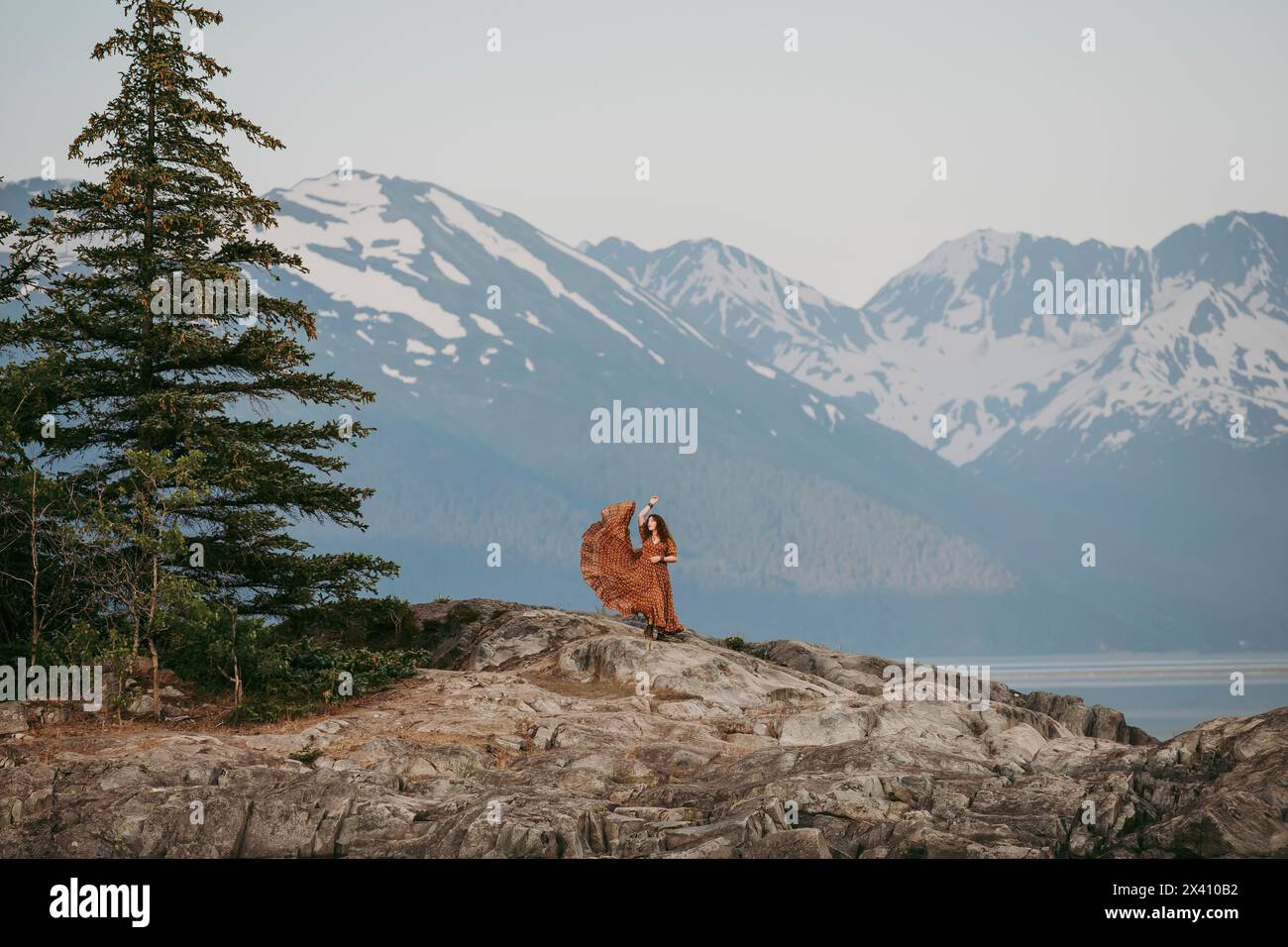 Teenage girl in a long dress dancing on rocks in Bird Point with the ...